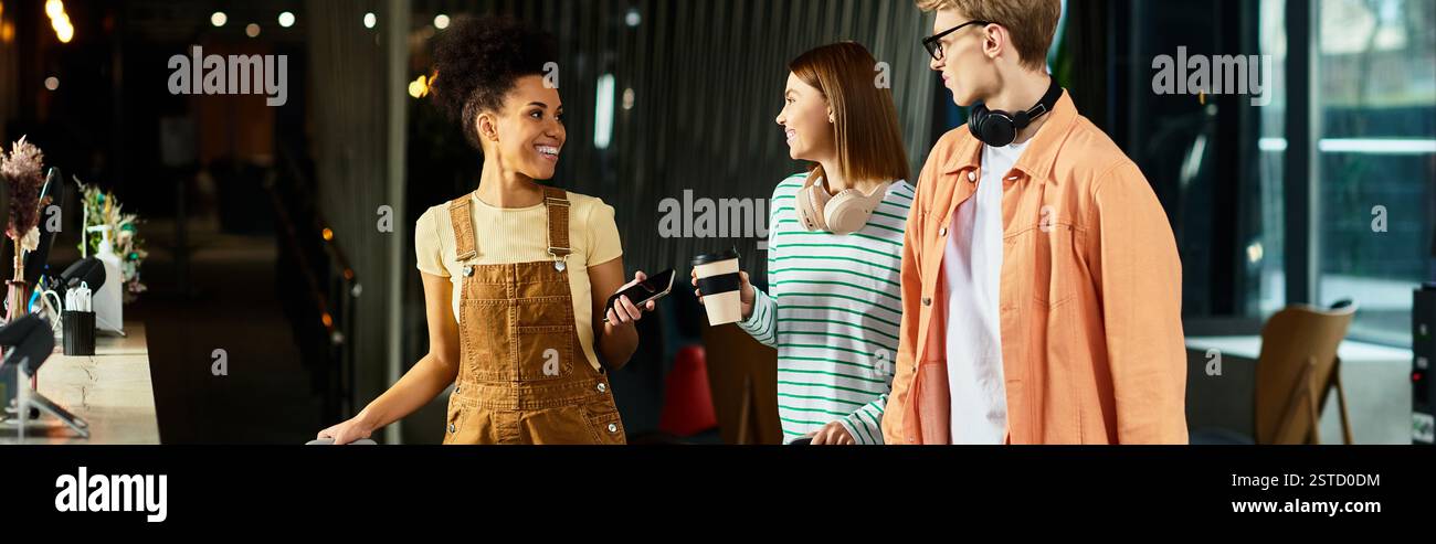 Three colleagues chat and smile while enjoying coffee at a hotel coffee ...