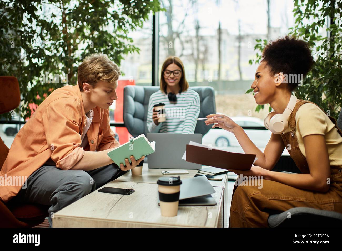 Three colleagues collaborate on a project while enjoying a business ...