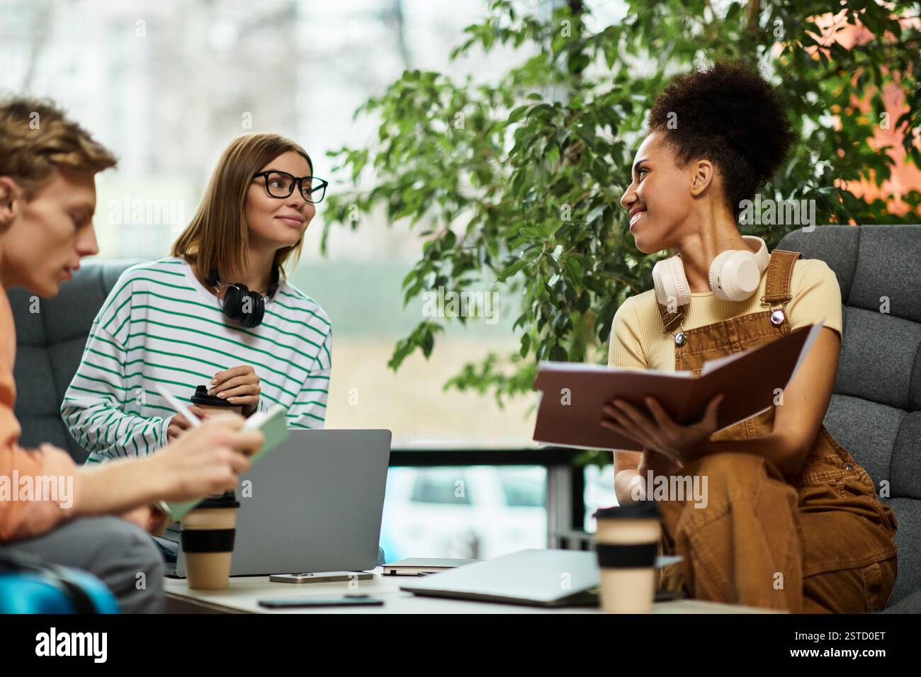 Three colleagues share ideas and relax in a hotel lounge while working ...