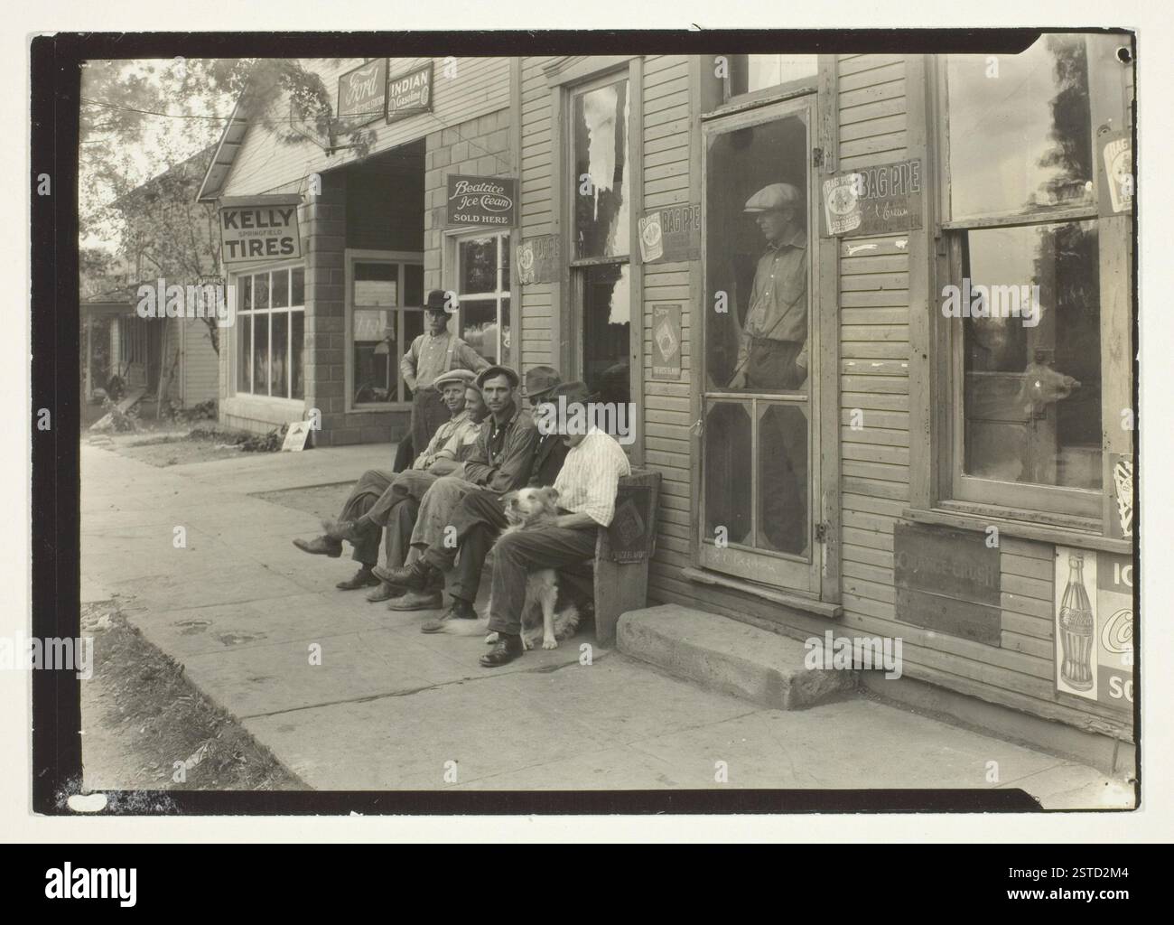 A gelatin silver print from 1905-1915 showing men sitting on a bench ...