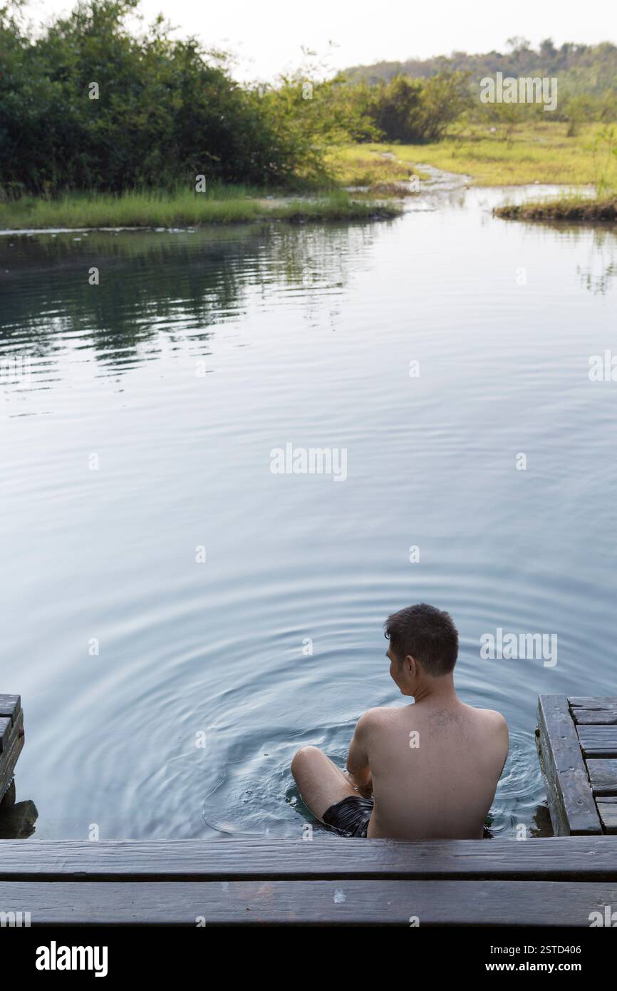 Myanmar, a man enjoying the hot springs at the Bayin Nyi Cave and hot ...