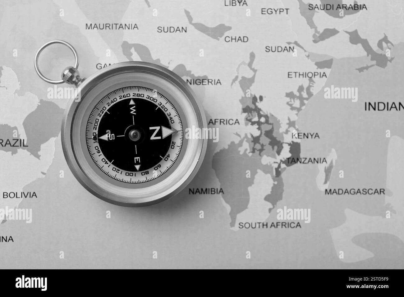 Compass on world map, top view. Toned in black-and-white Stock Photo ...