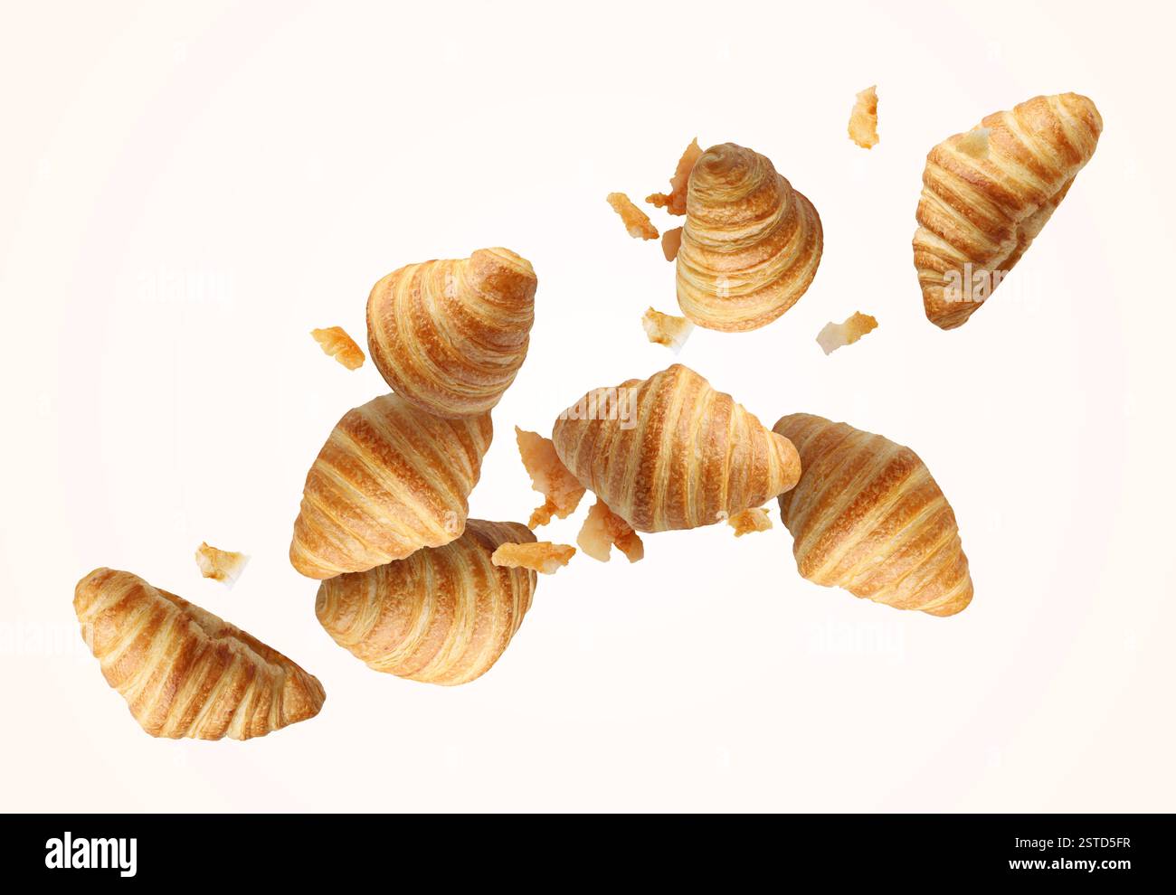Delicious croissants and crumbs in air on white background. Puff pastry ...