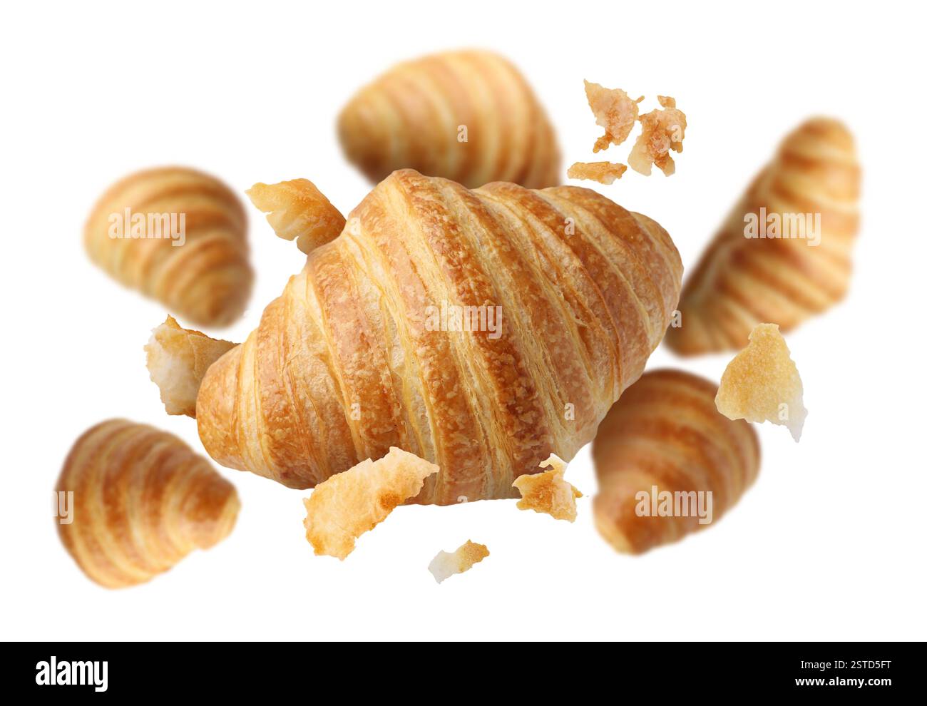 Delicious croissants and crumbs in air on white background. Puff pastry ...