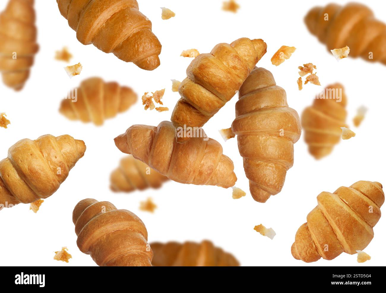 Delicious croissants and crumbs in air on white background. Puff pastry ...