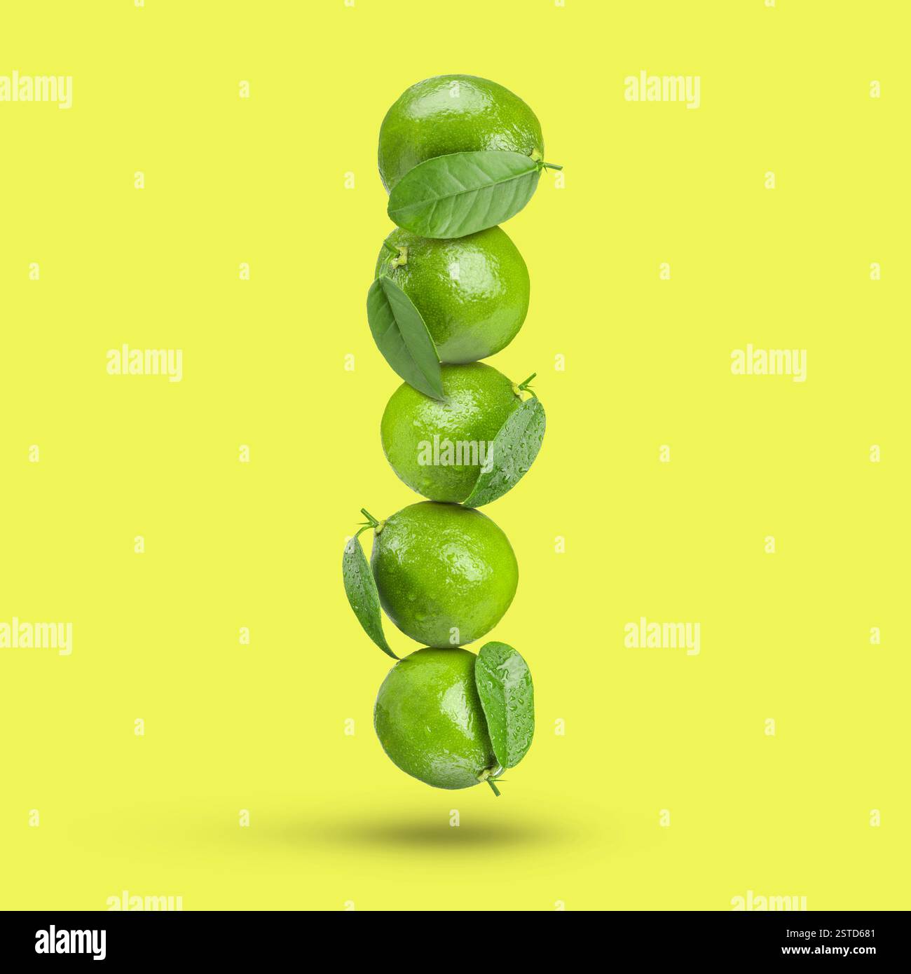 Fresh whole lime falling on yellow background Stock Photo - Alamy