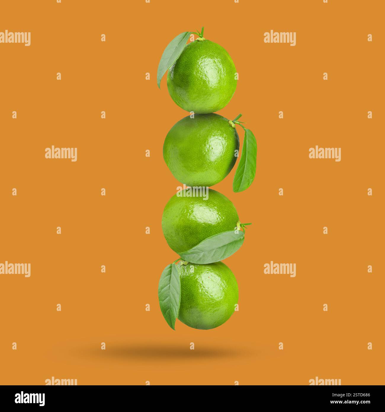 Fresh whole lime falling on dark orange background Stock Photo - Alamy