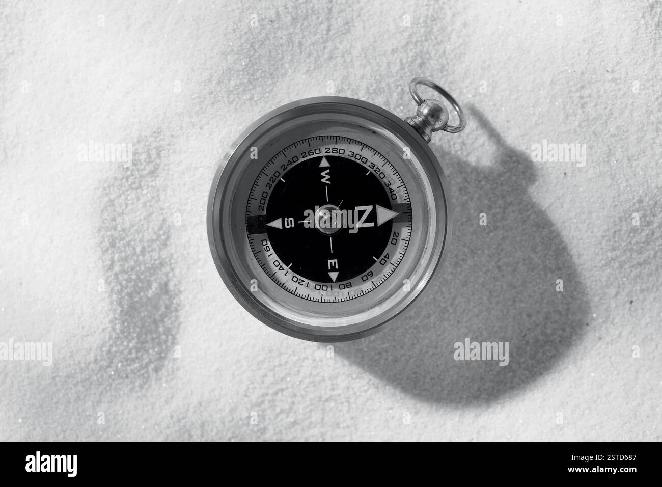 Compass on sand, top view. Toned in black-and-white Stock Photo - Alamy
