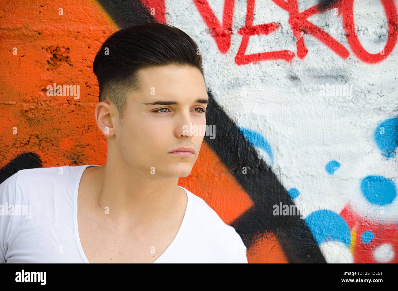 Good looking young man against graffiti wall Stock Photo - Alamy