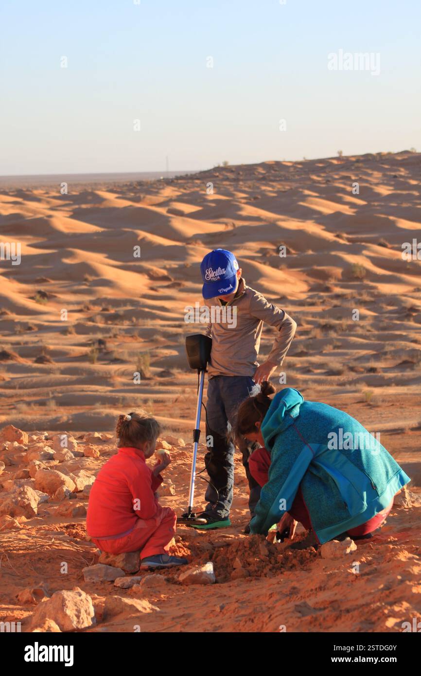 A woman and two small children search for treasure together in the ...