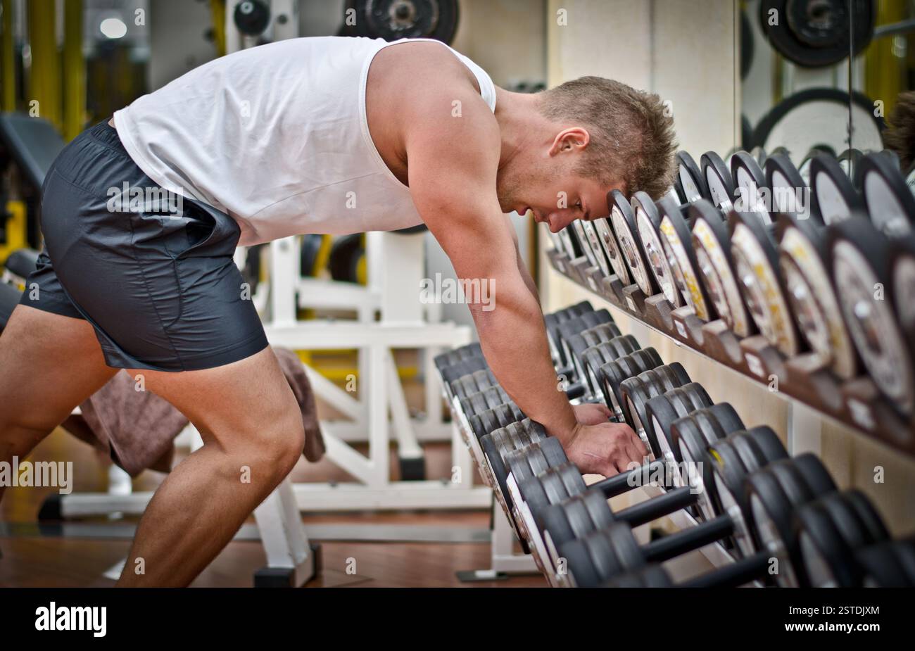 Handsome young man resting after workout in gym Stock Photo - Alamy