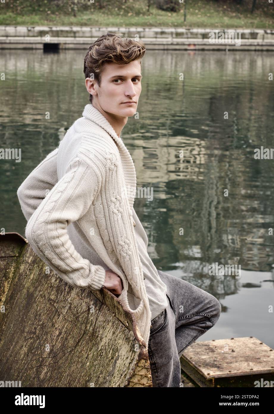 Attractive young man standing against rusty metal next to river hi-res ...