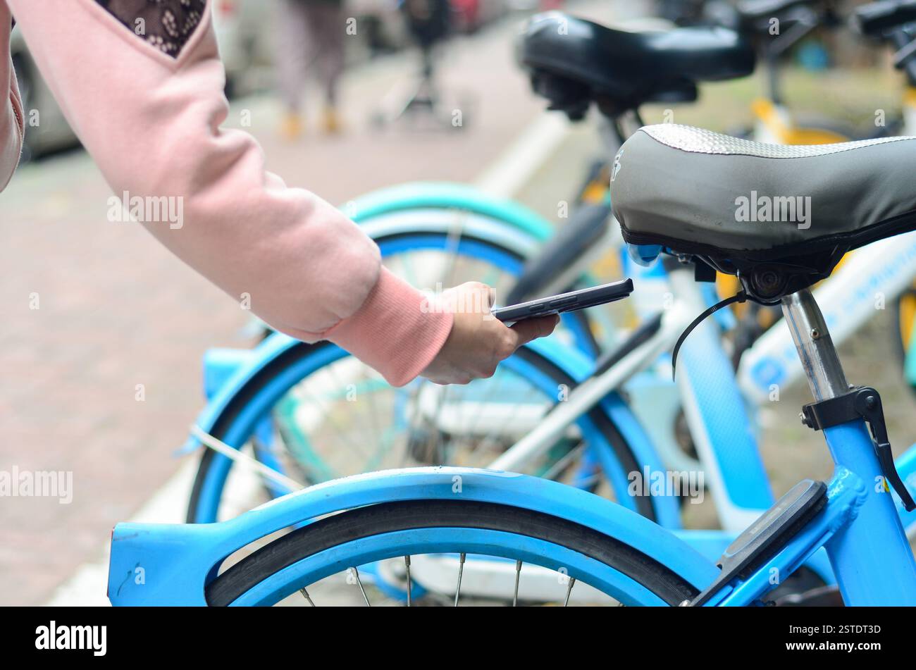 People use smart phone to scan the QR code on a shared bike to unlock ...