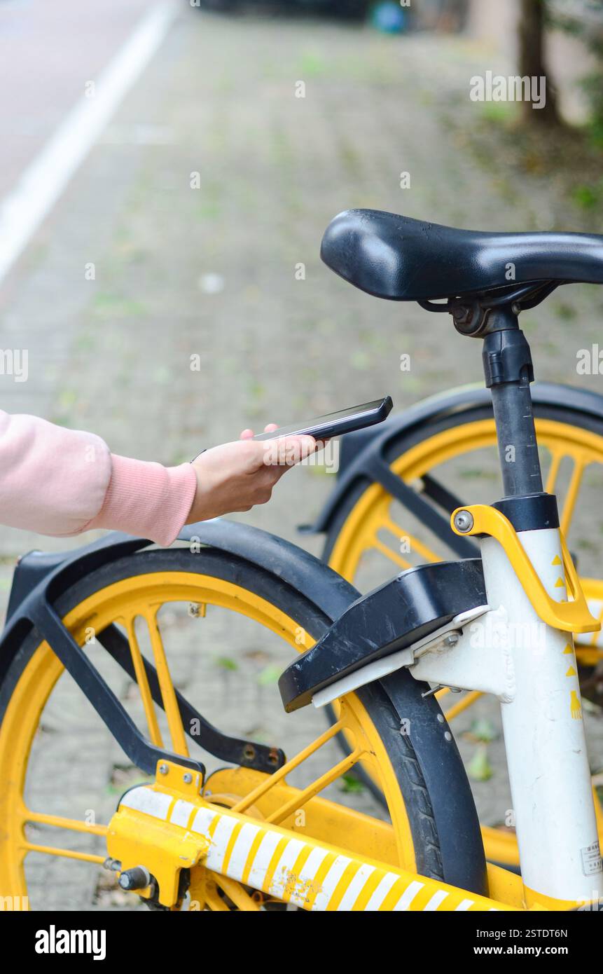 People use smart phone to scan the QR code on a shared bike to unlock ...