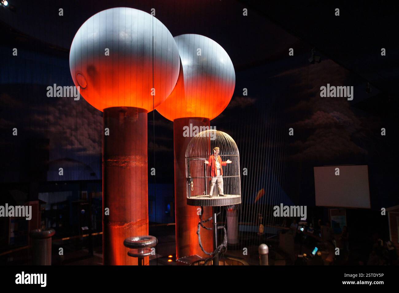 Museum exhibit in Boston. Man in a cage stands between two large ...