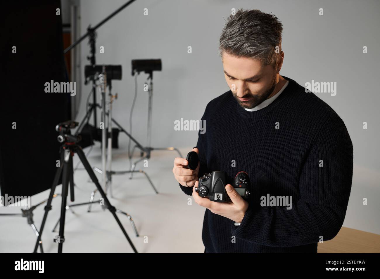 A dedicated man carefully tweaks his camera settings in an organized ...