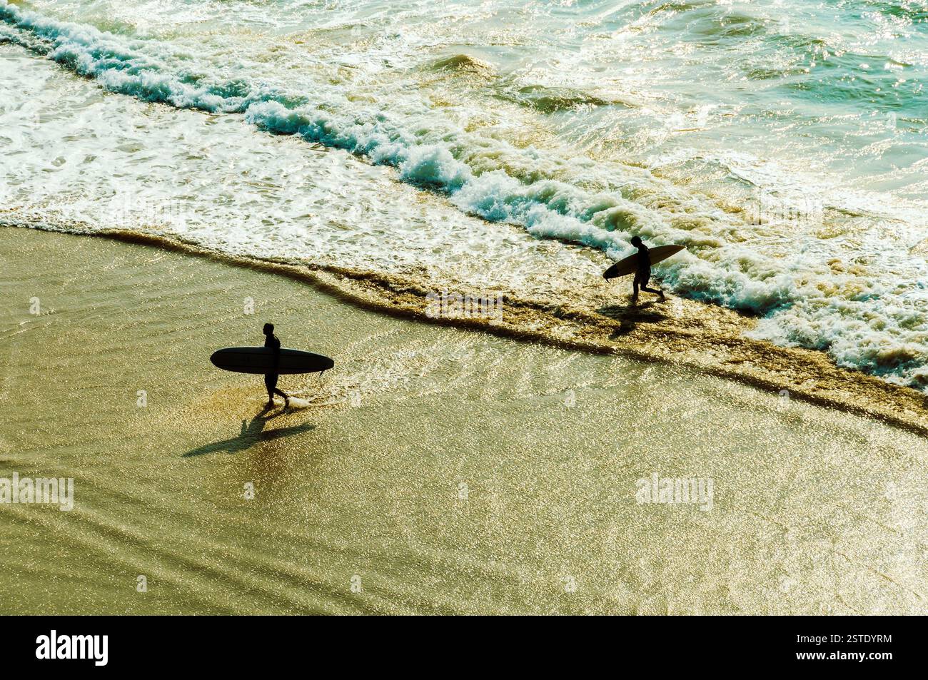 Two surfers going back to the beach Stock Photo - Alamy