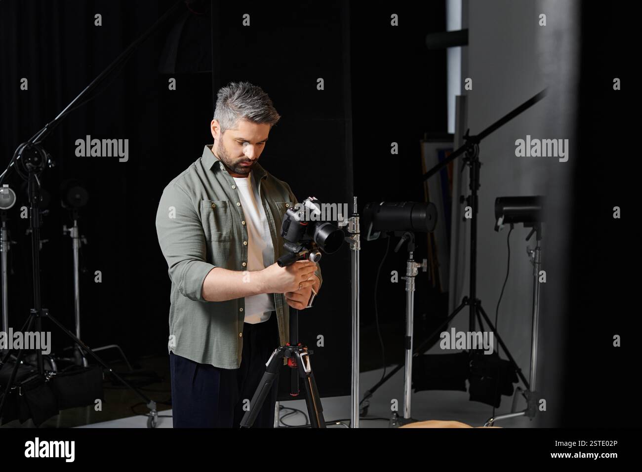 A focused man is preparing his camera gear in a sleek photography ...