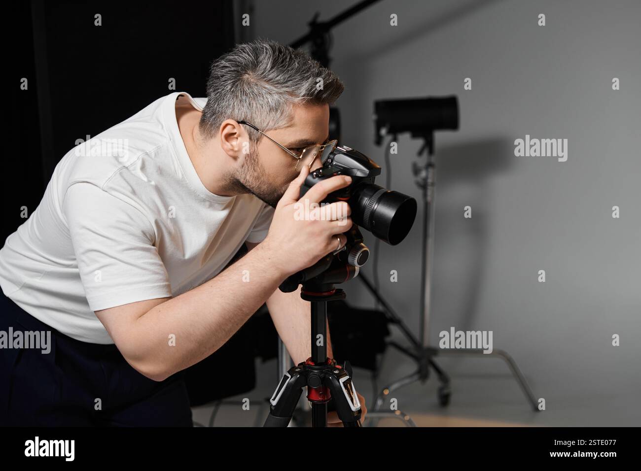 A man concentrates on his camera adjustments, preparing to capture ...