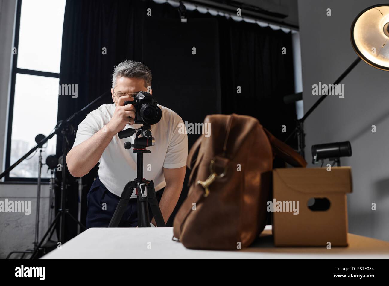 A skilled individual diligently captures his passion for photography in the studio Stock Photo ...