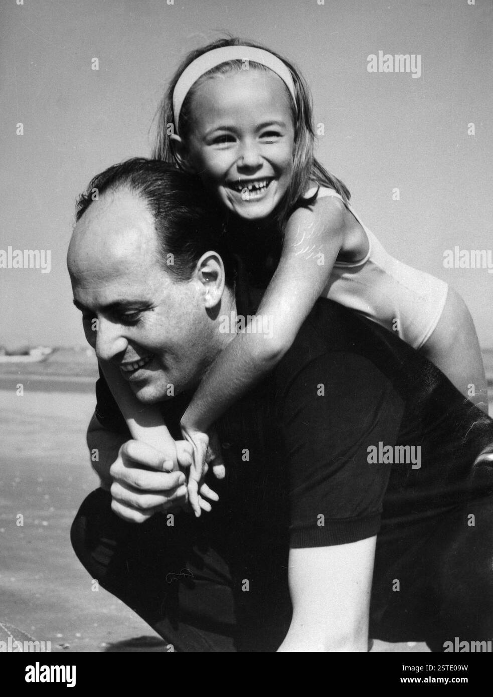 Italian film director Roberto Rossellini playing with her daughter ...