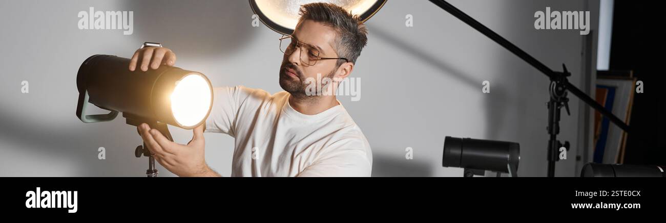 Man focuses intently on adjusting the lighting equipment in a ...