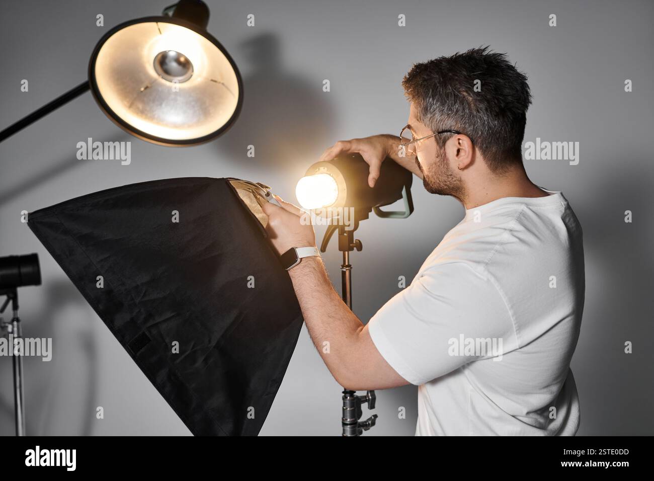 An expert in photography sets up a light source to enhance the visual ...
