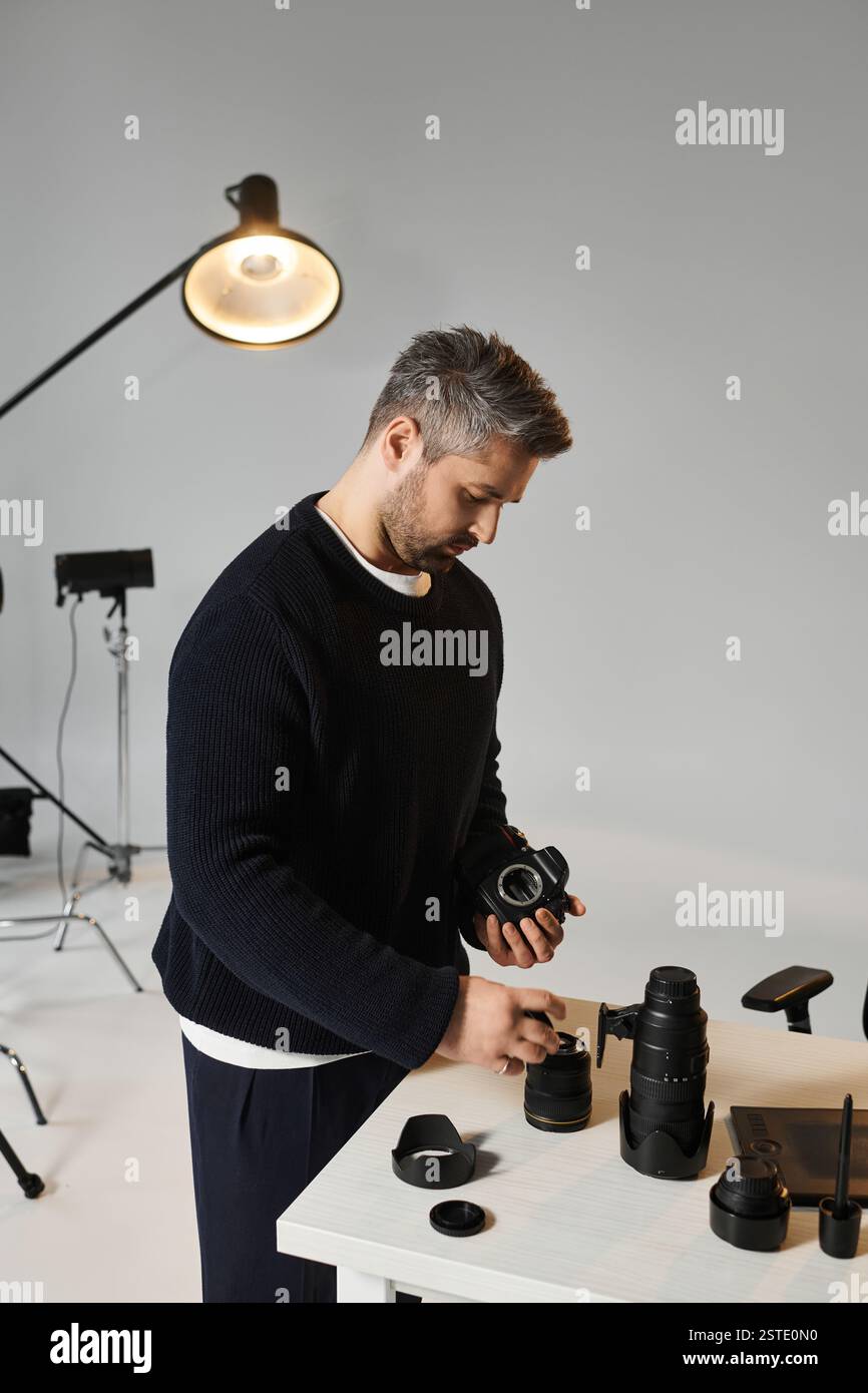 Focused individual adjusts camera lenses and gear while preparing for a ...