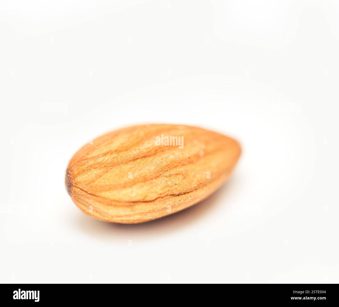One almond closeup isolated on white background Stock Photo - Alamy