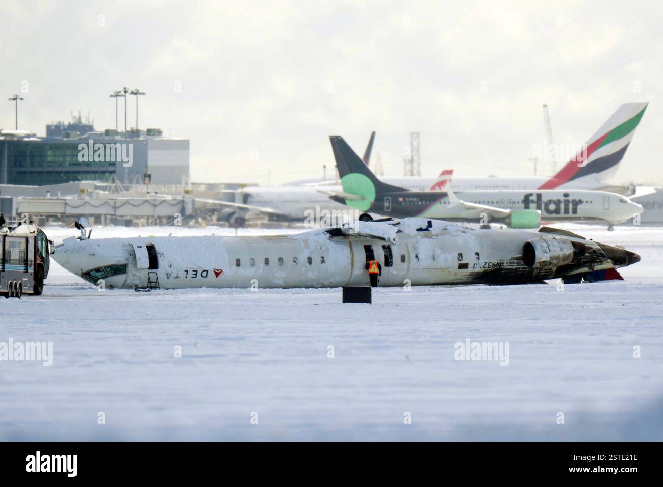 A Delta Air Lines plane lies upside down at Toronto Pearson Airport on ...