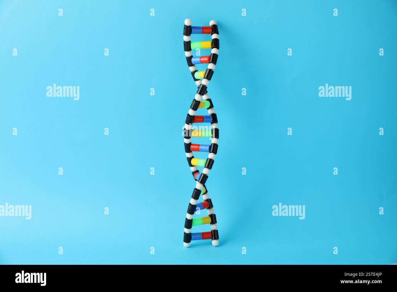 DNA structure model on light blue background Stock Photo - Alamy