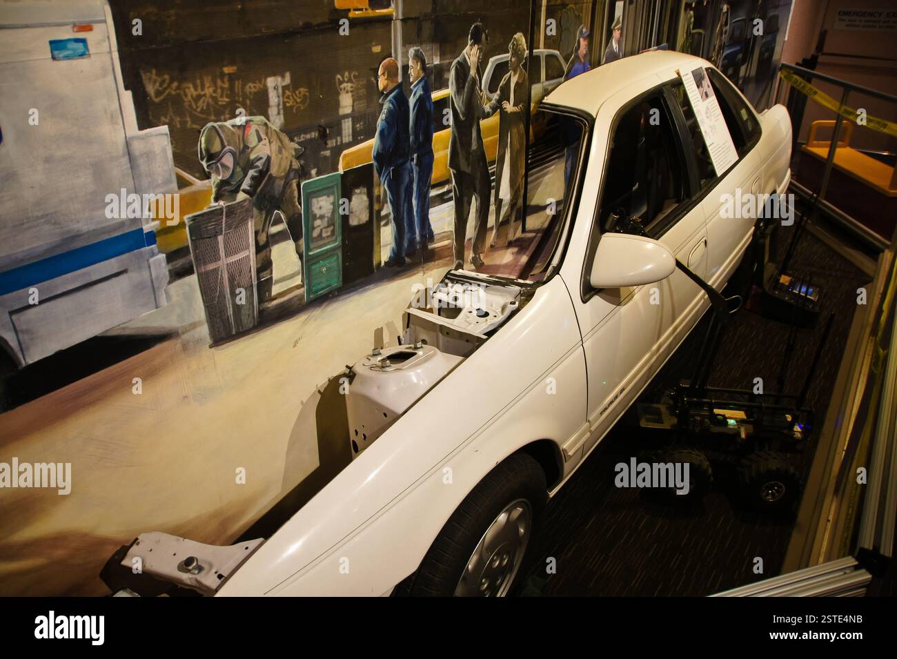 Boston car crash exhibit. Crushed white sedan on display. Police tape ...