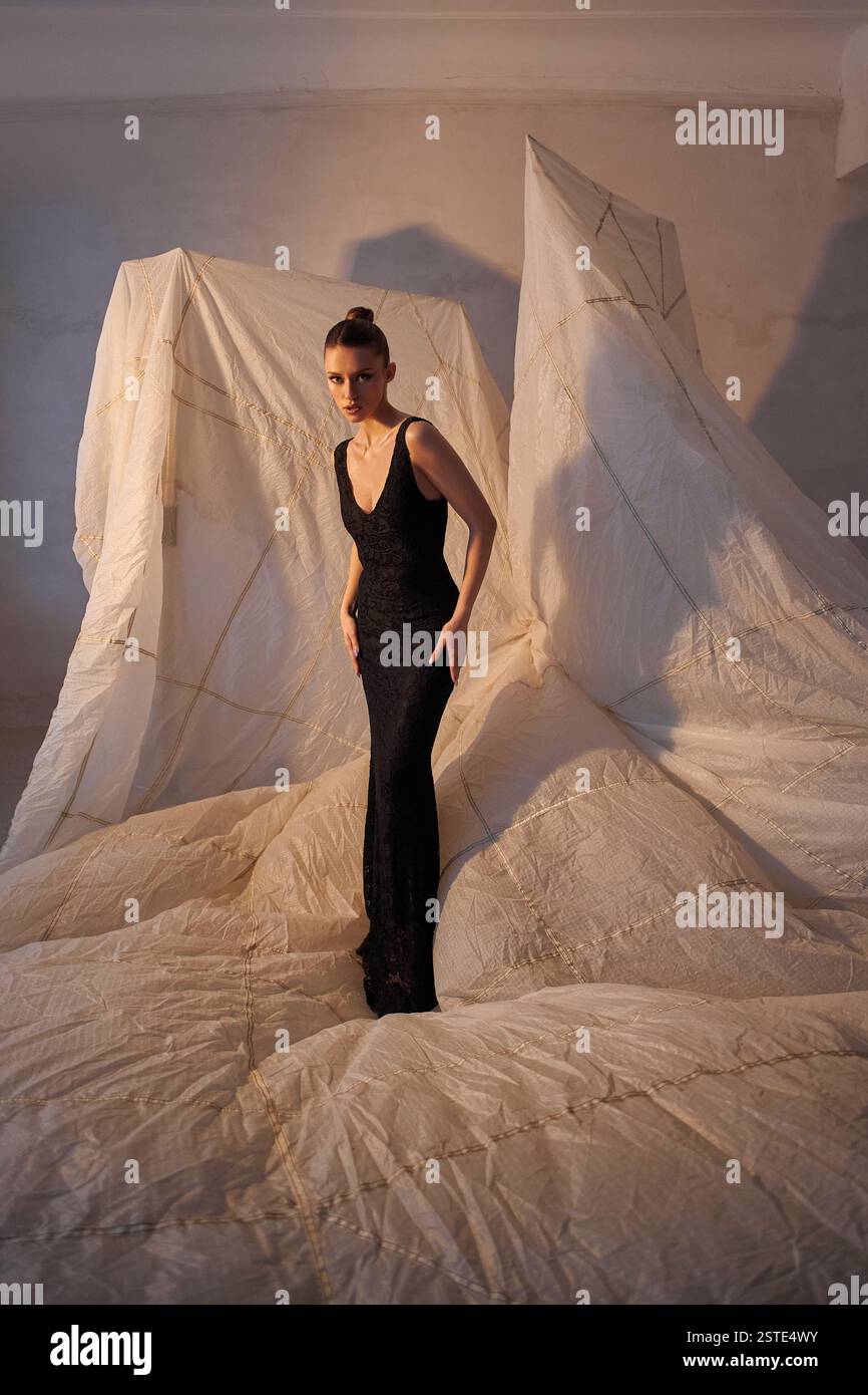 Striking model stands gracefully in a form-fitting black gown ...