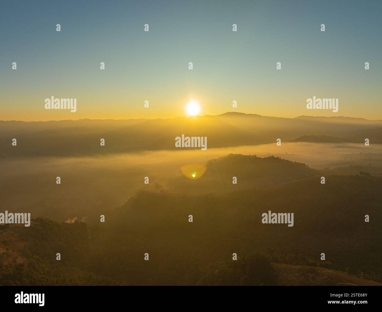 Aerial View of beautiful sunrise above the mist in the valley. There is ...