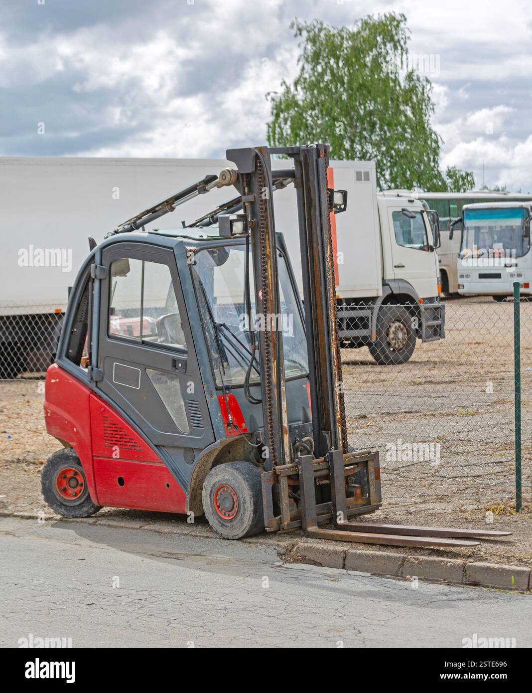 Red Forklift Tuck Vehicle With Enclosed Cabin in Front of Cargo Truck ...