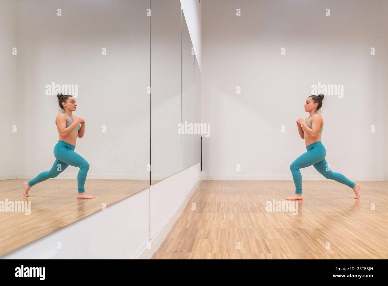 Side view of focused woman performs the Anjaneyasana yoga pose in front ...