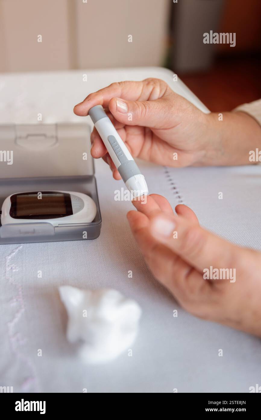 A person prepares to use a glucometer to check their blood sugar level ...