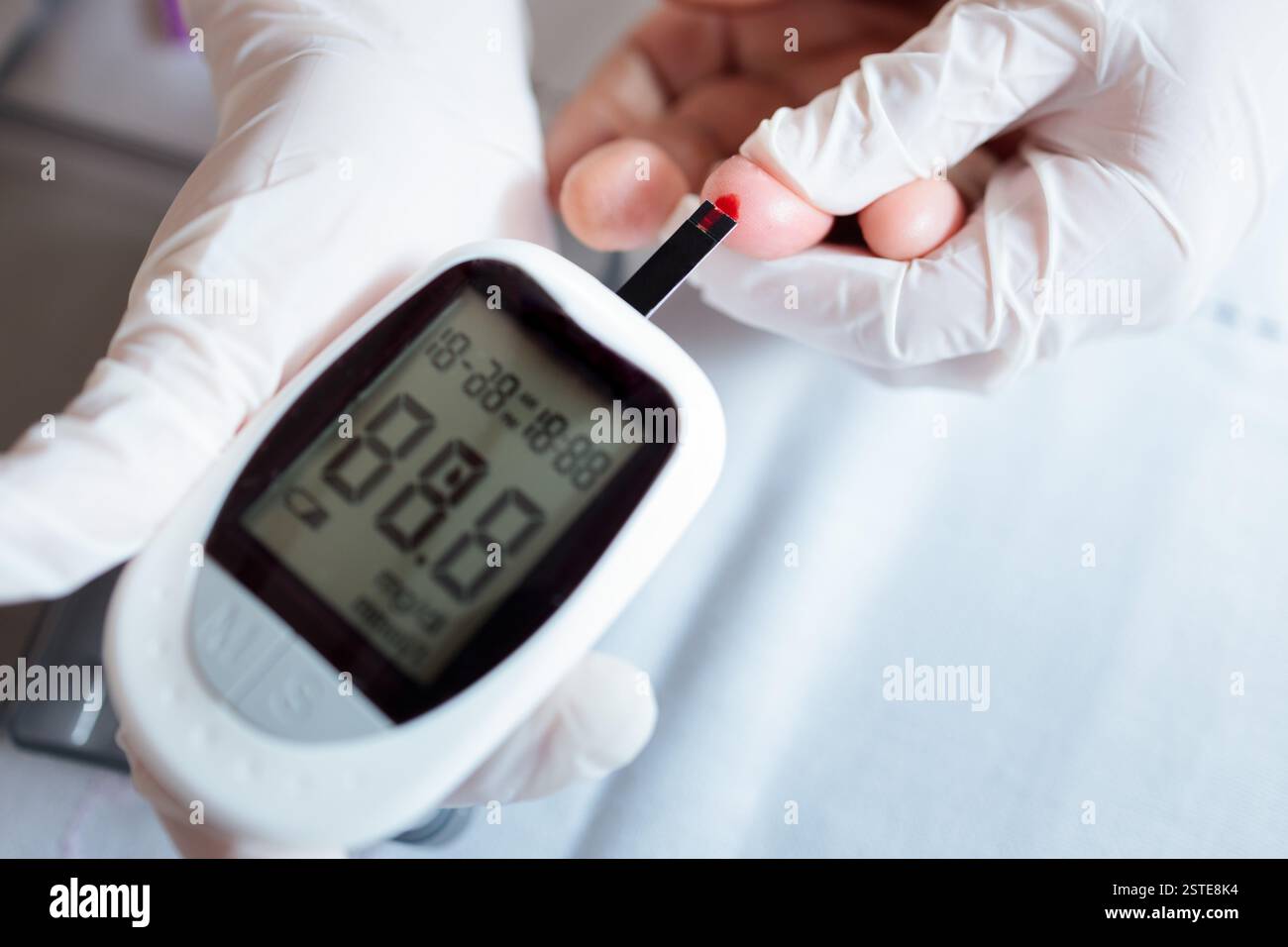 A healthcare worker measures glucose levels in a patient's blood sample ...