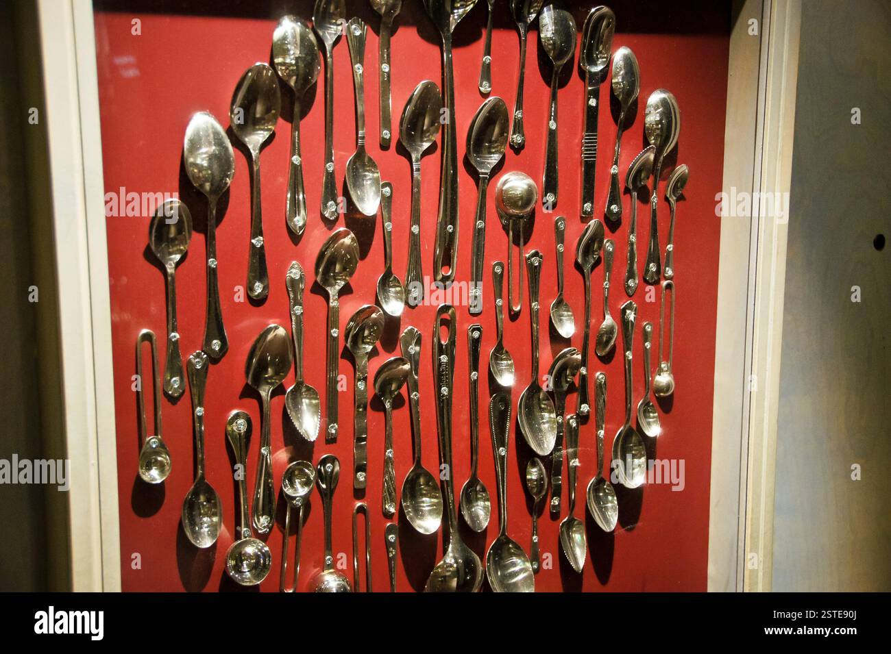 Spoons arranged in a circular pattern on a red background. Diverse ...