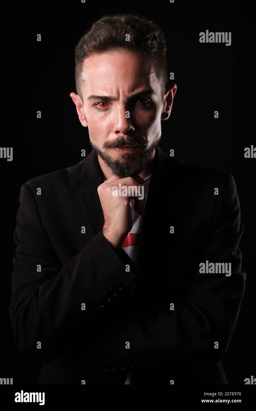 A serious-looking man in a suit with red contact lenses standing ...