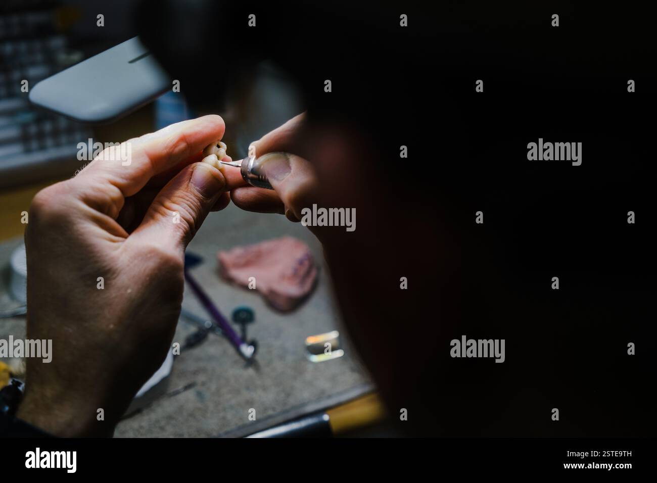 From above a cropped unrecognizable craftsman works with precision on a ...