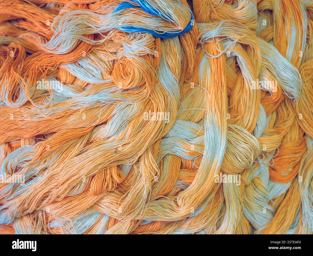 A close-up image showcasing a vibrant assortment of orange yarns ...