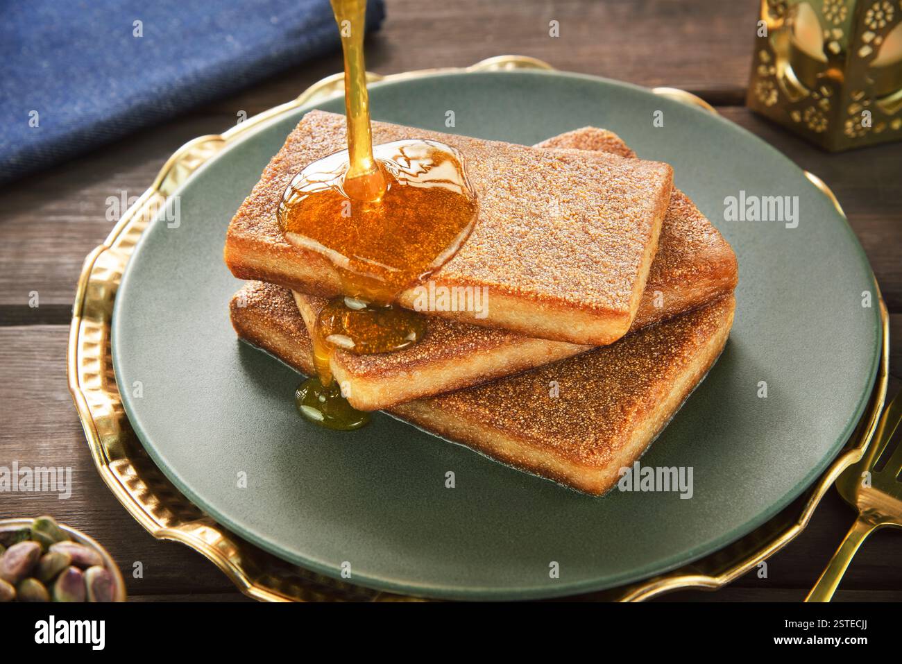 Arabic cuisine; Pouring syrup on Middle Eastern Semolina cake "Basbousa ...