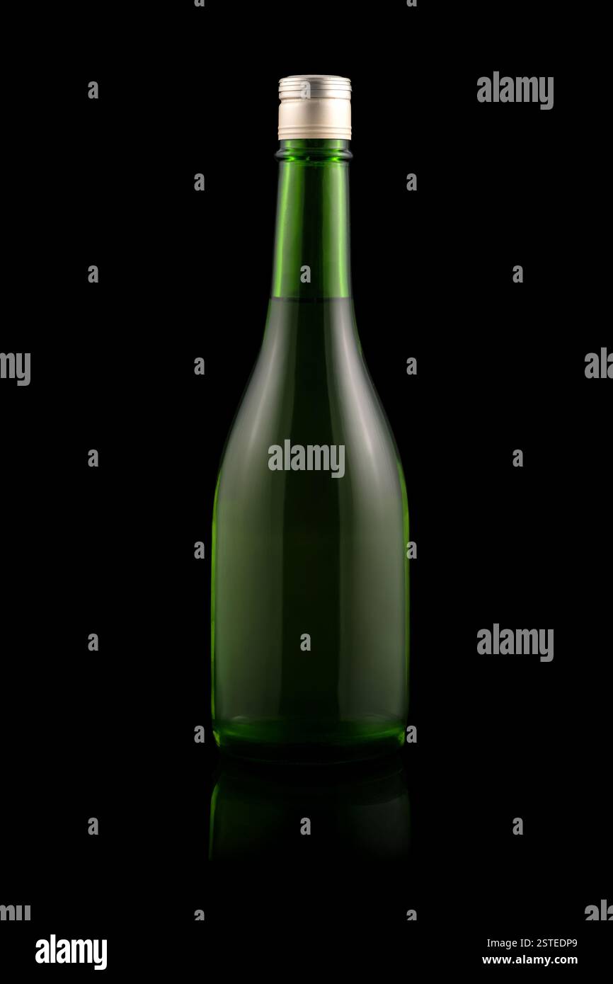 An elegant green glass wine bottle stands against a reflective black ...