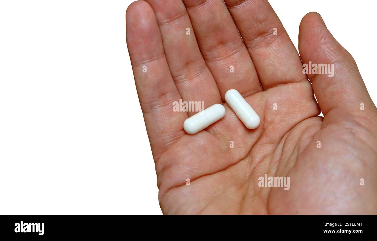 Two pills on male hand. Drug addiction concept Stock Photo - Alamy