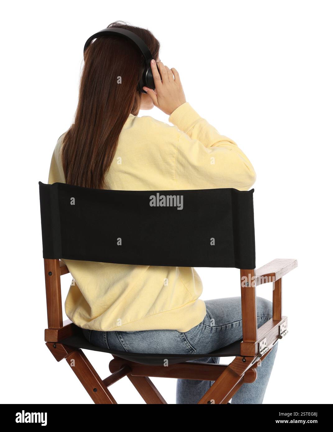 Woman with headset sitting in director's chair on white background ...