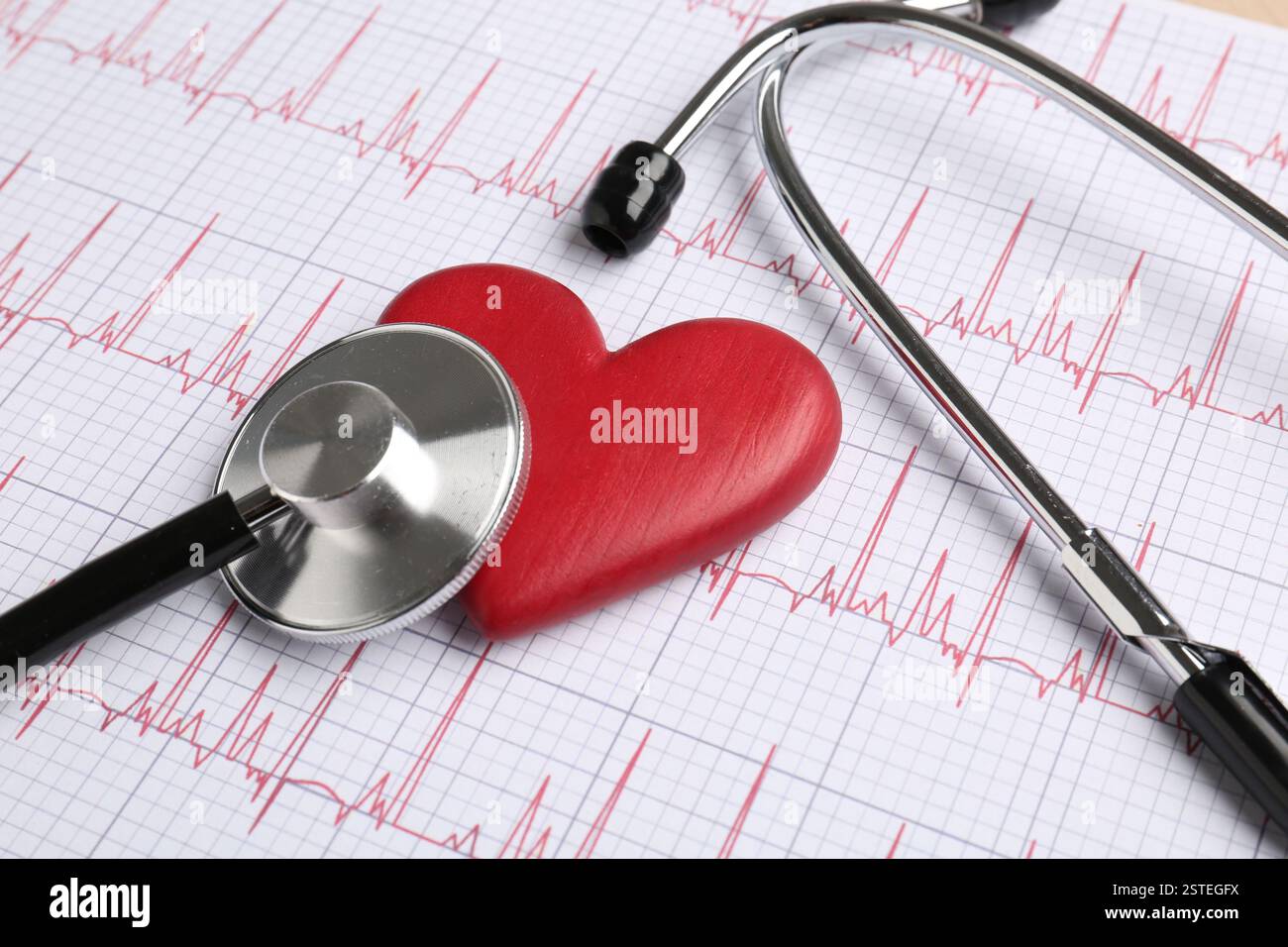 Cardiology. Stethoscope and red decorative heart on paper with ...