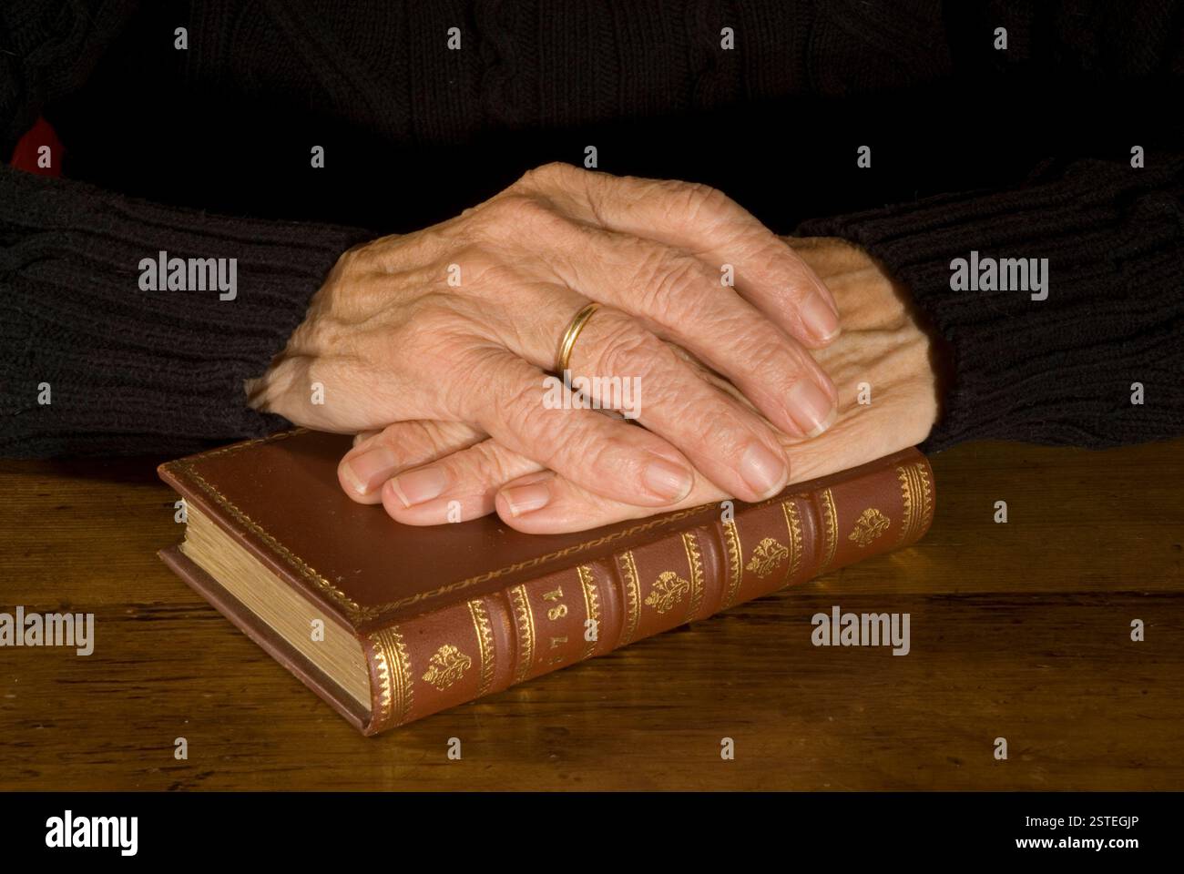 Old hands resting at antique bible Stock Photo - Alamy