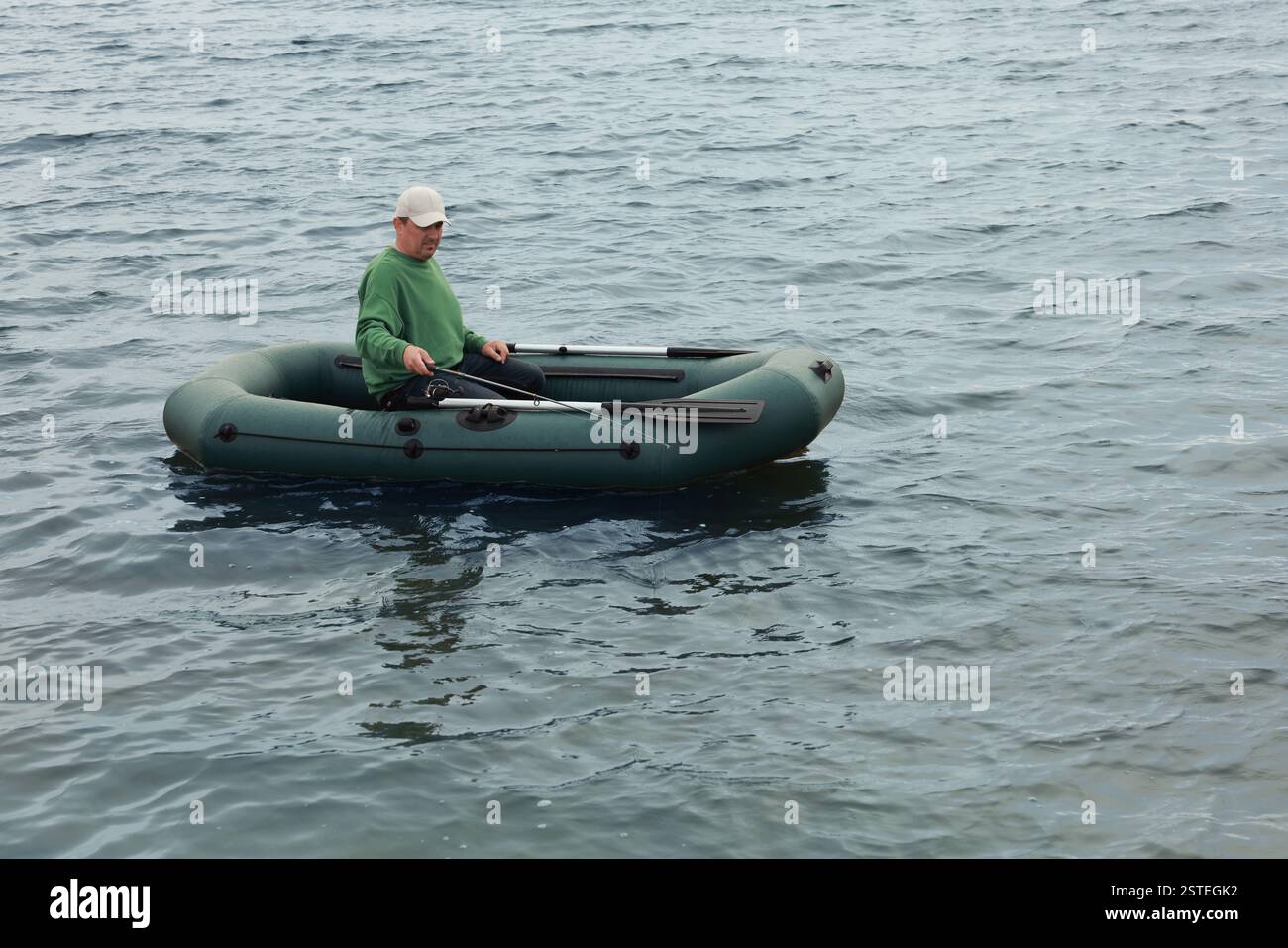 Man fishing with rod from inflatable rubber boat on river Stock Photo ...