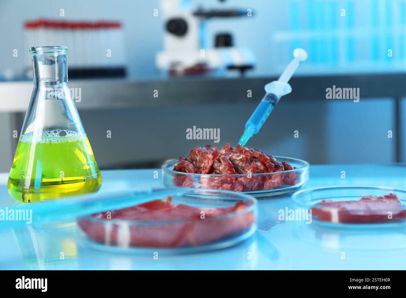 GMO concept. Different products, syringe and flask on table in ...